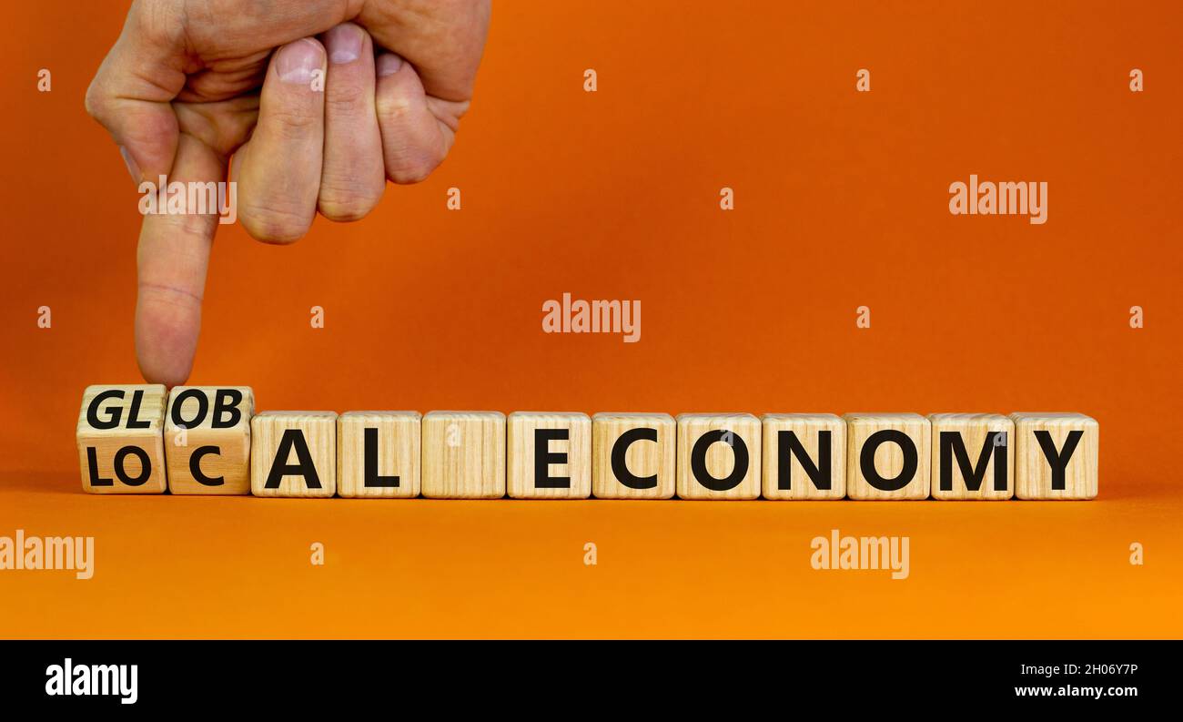 Local or global economy symbol. Businessman turns wooden cubes and ...