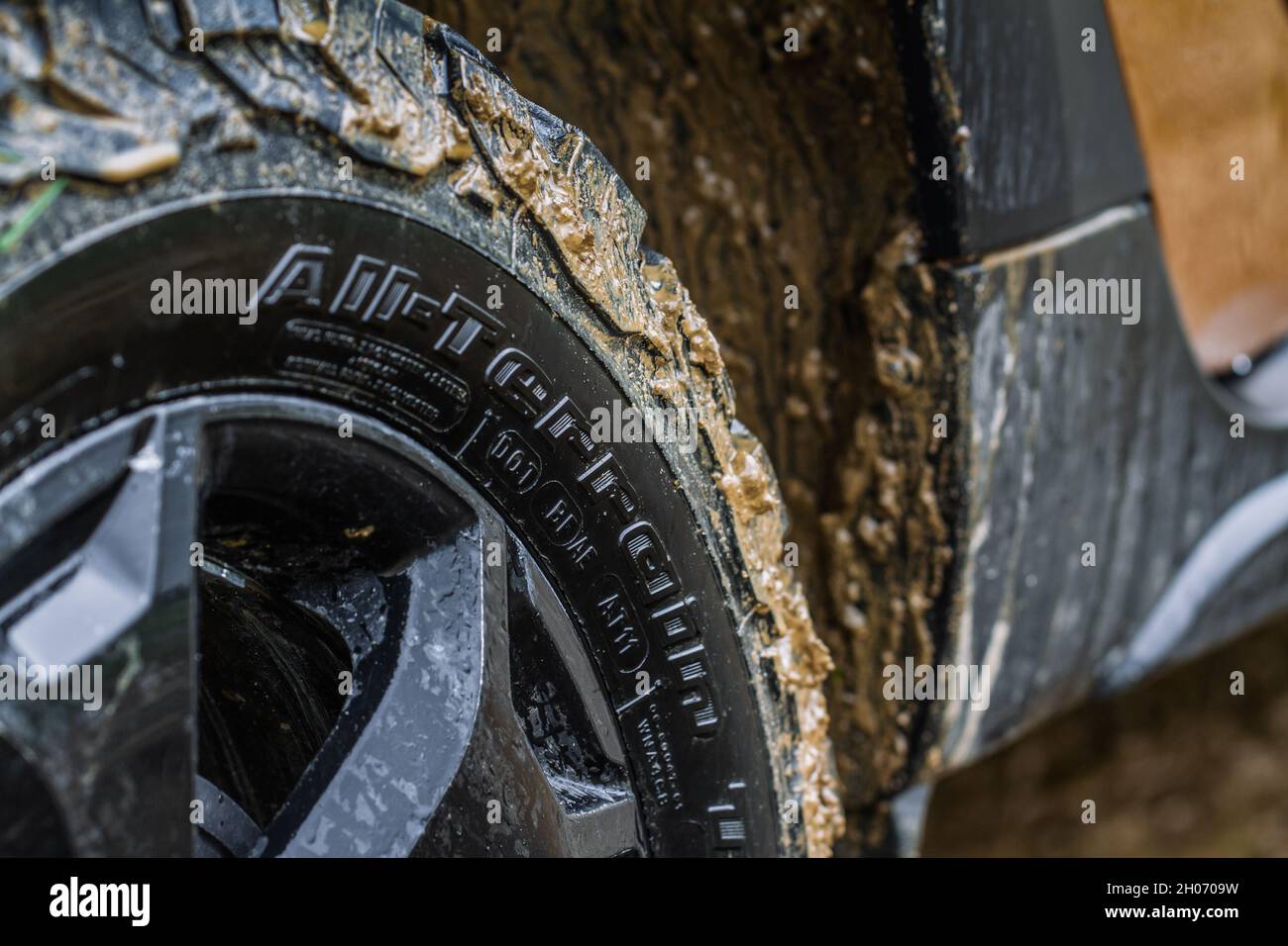 Сlose up view of all-terrain tires on the gravel road with a lot of ...