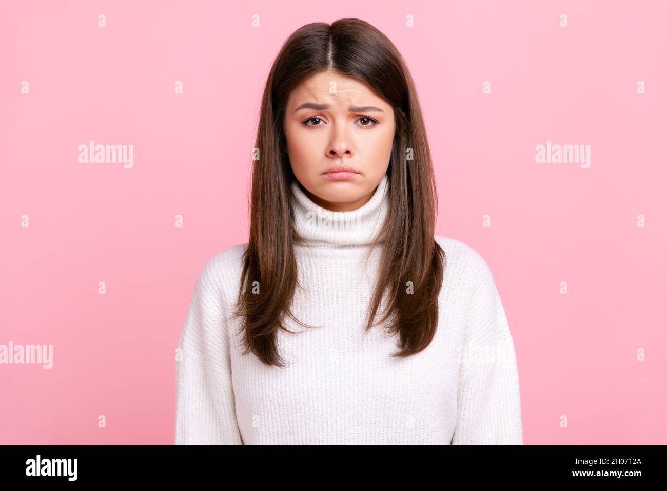 Portrait of unhappy sad brunette female looks at camera, expresses ...