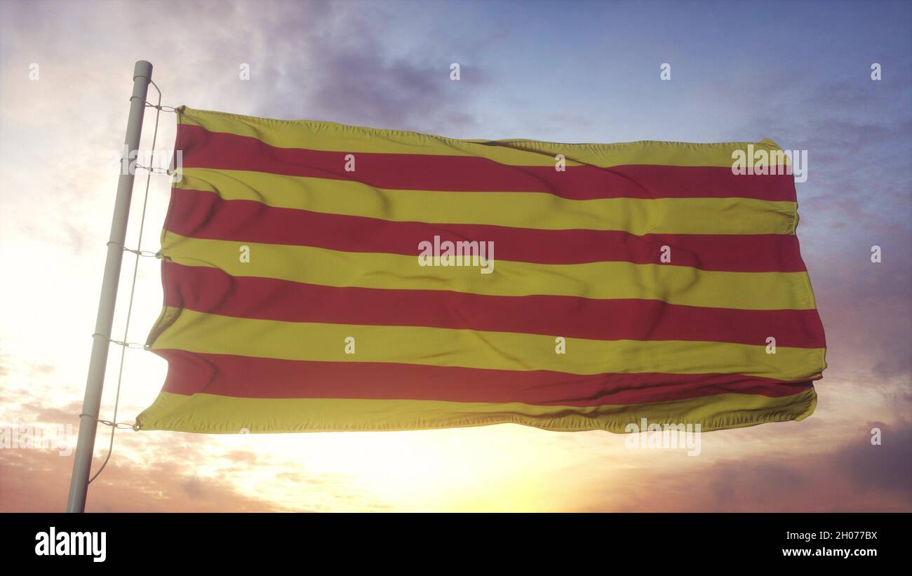 Roussillon flag, France, waving in the wind, sky and sun background. 3d ...