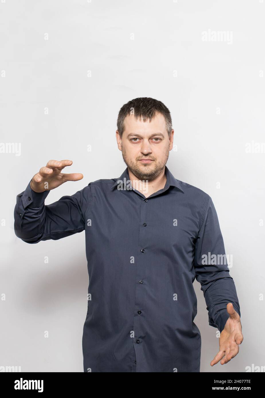 The man holds an invisible ball with his hands, one hand up the other ...