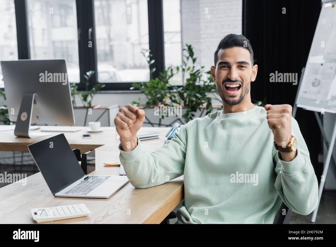 Excited muslim businessman showing yes gesture near calculator and ...