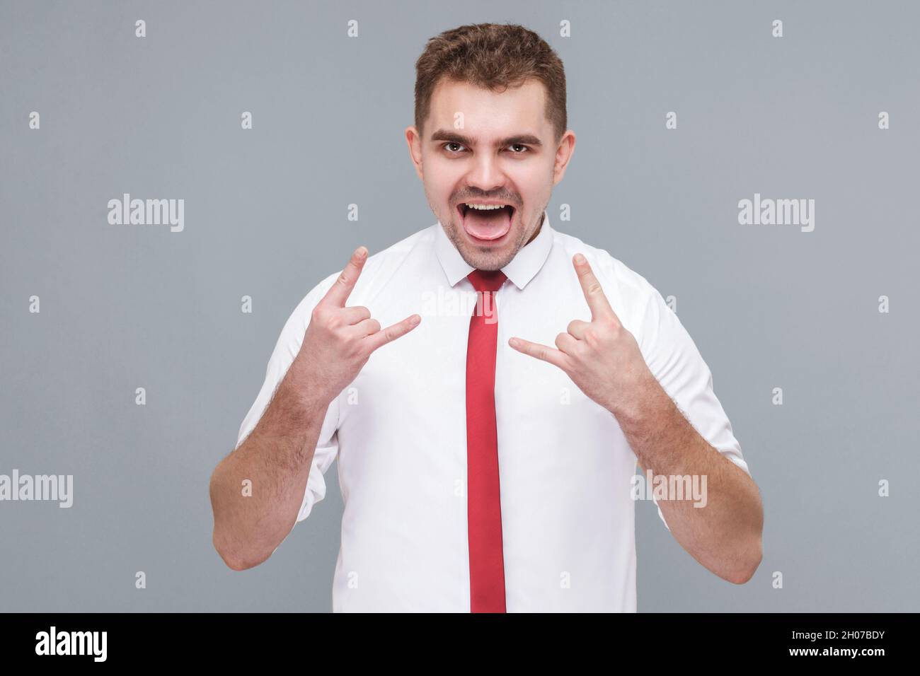 Portrait of young handsome man in white shirt and tie standing with ...