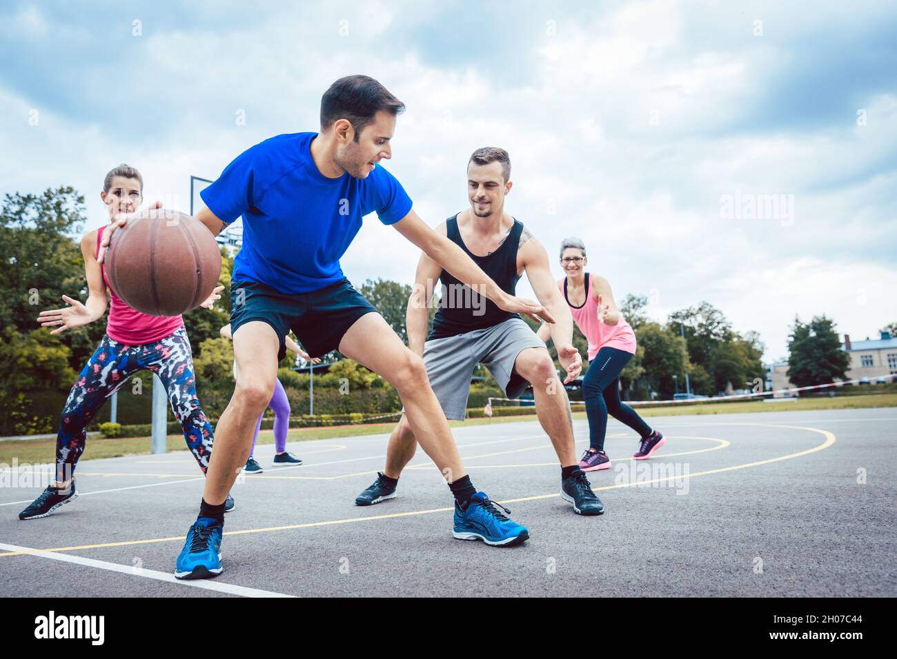 Group of friends are playing basketball outdoors Stock Photo - Alamy