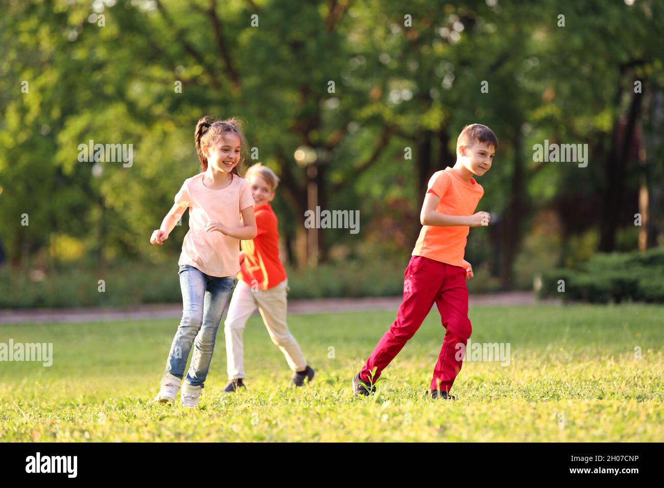 Cute little children playing together outdoors on sunny day Stock Photo ...