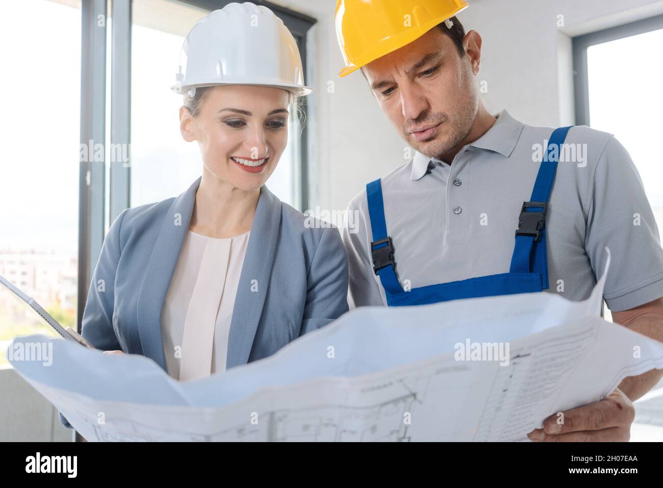 Construction worker and architect looking at plan on site Stock Photo ...