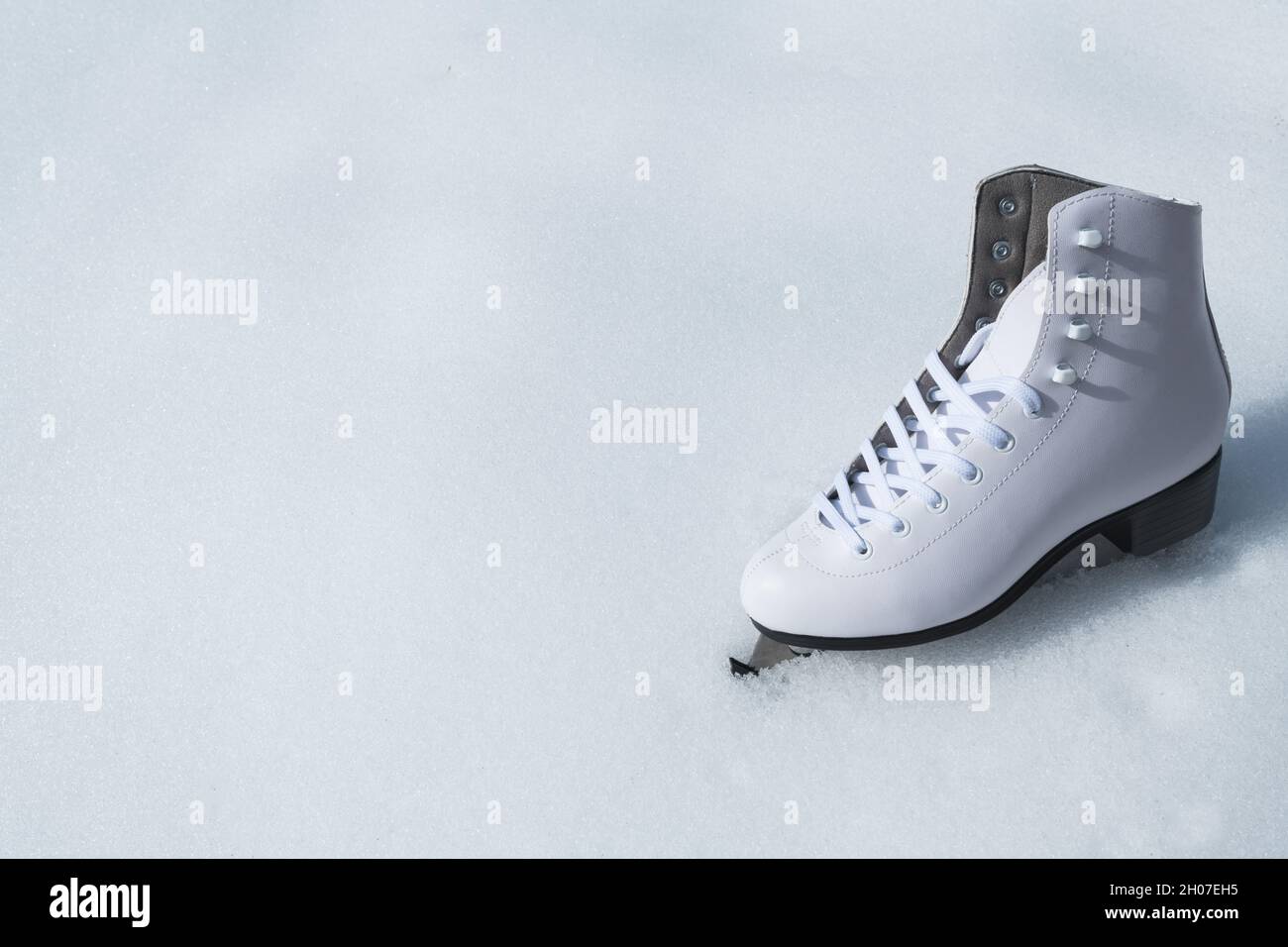 white ice skate sticking in natural snow Stock Photo - Alamy