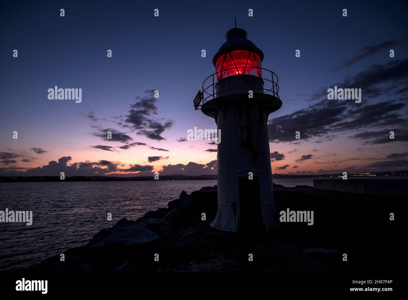 Brixham harbour lighthouse in Brixham, Devon at sun set on a summer ...