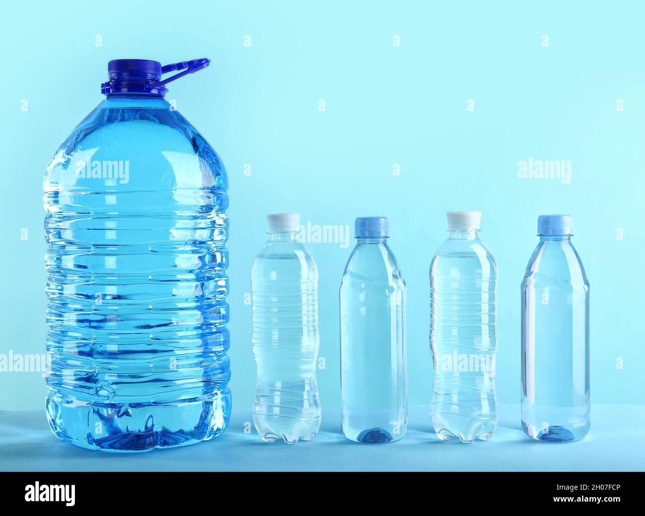 Large and small bottles with pure water on color background Stock Photo ...