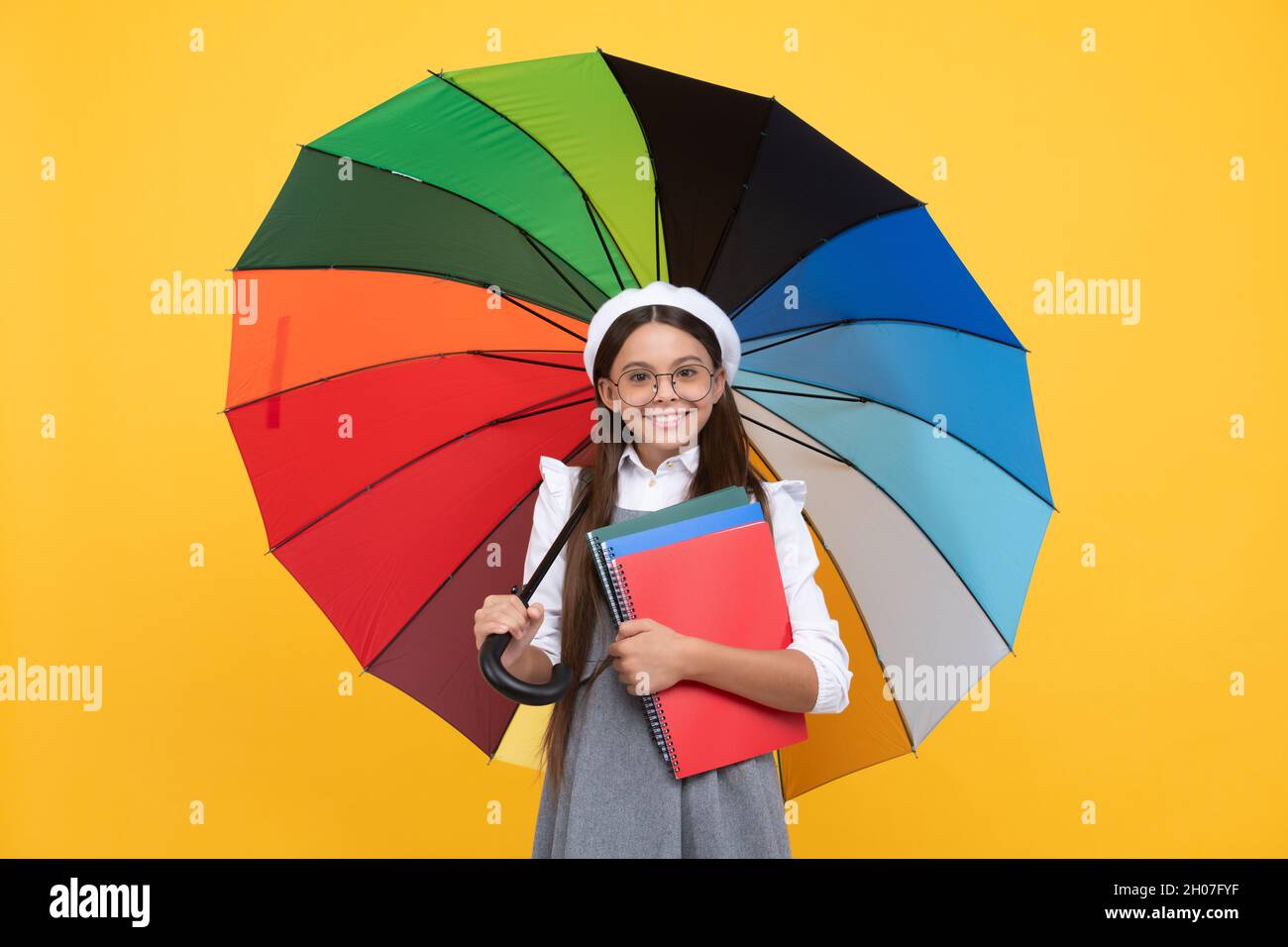 education. teen child under colorful parasol. kid in beret with rainbow ...