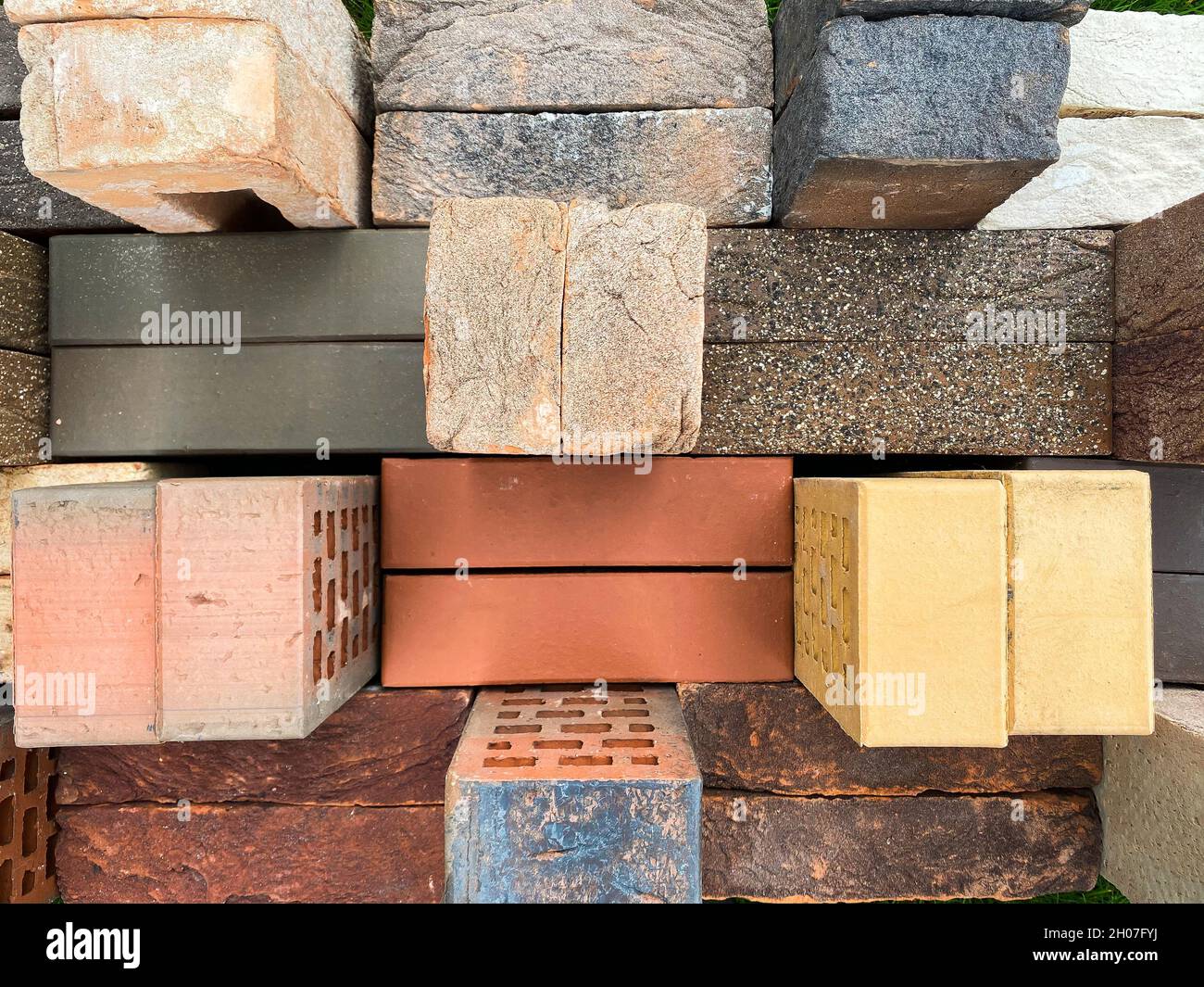 Different types of bricks stacked beautifully on green grass Stock ...