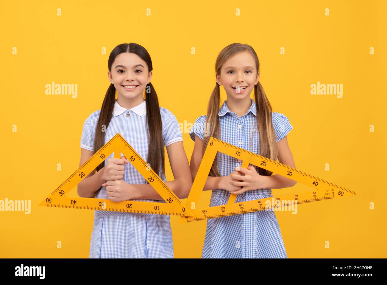 Geometry is for triangles. Happy kids hold triangular rulers. Geometry ...