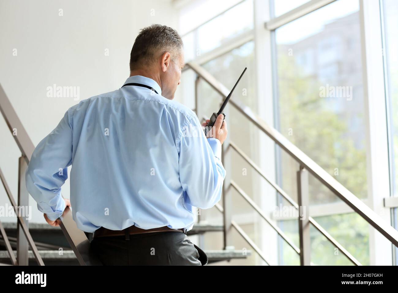 Male security guard using portable radio transmitter indoors Stock ...
