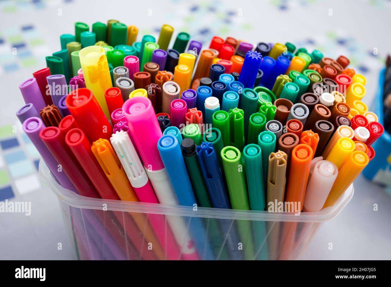 Large group of colorful felt pens in plastic box on table, ready for ...