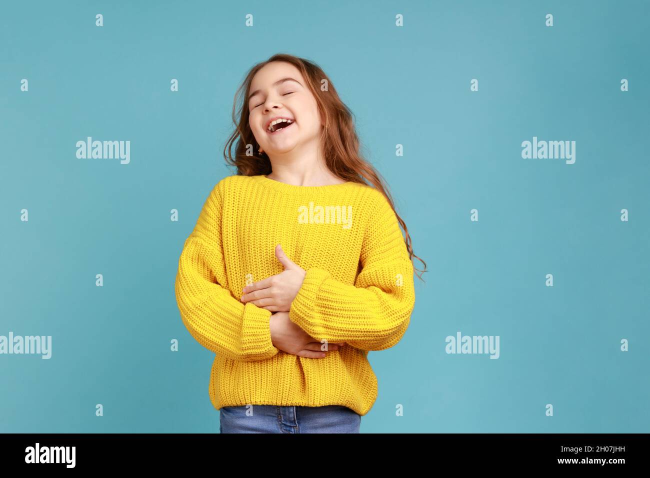 Portrait of happy positive little girl laughing out loud, holding her ...