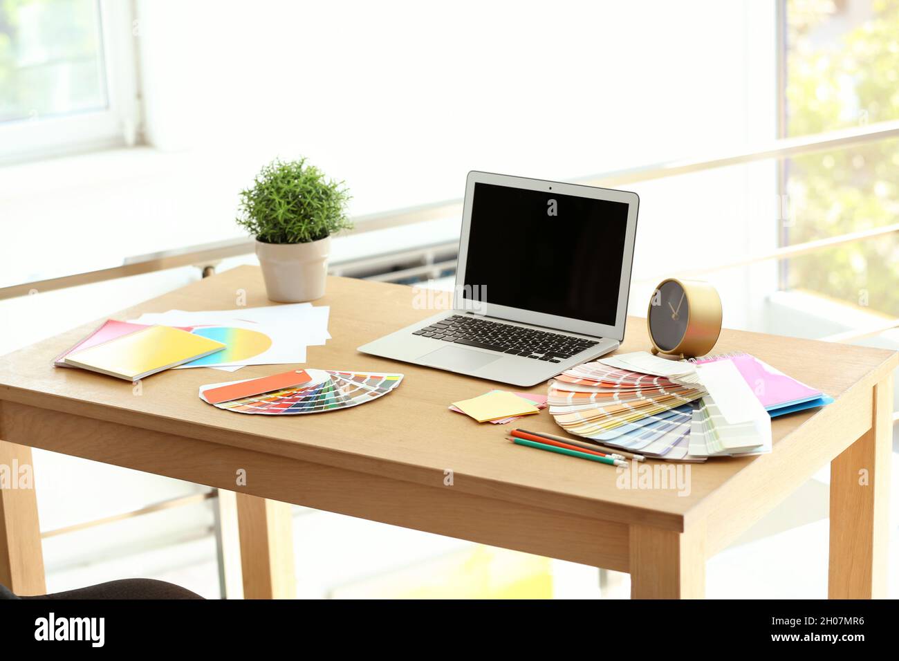 Designer's workplace with laptop and paint color palette samples on ...