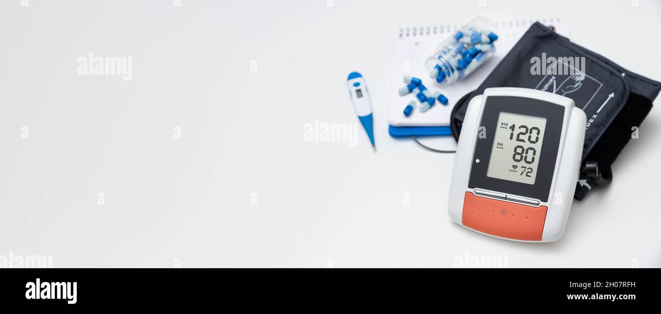 Digital blood pressure monitor on white background, copy space banner ...