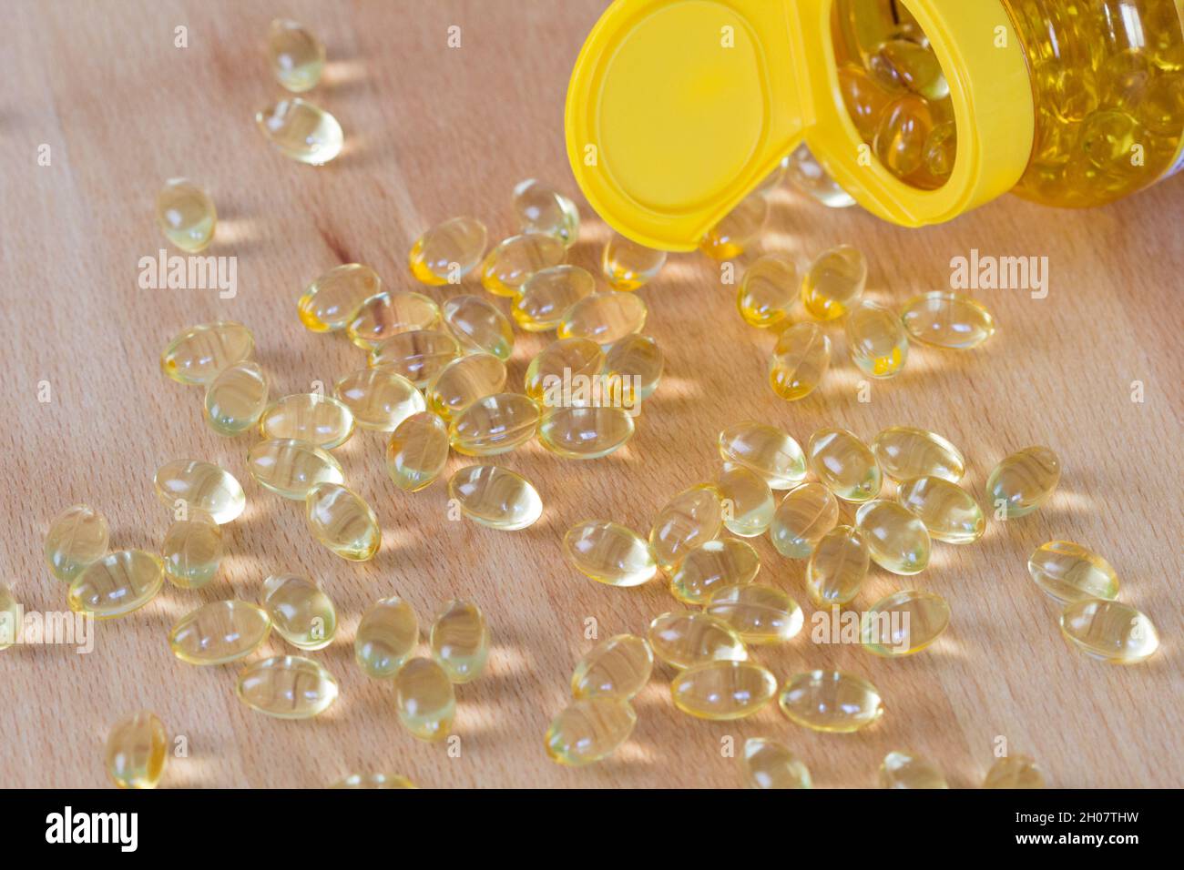 Fish oil omega pills spilled from a bottle Stock Photo - Alamy