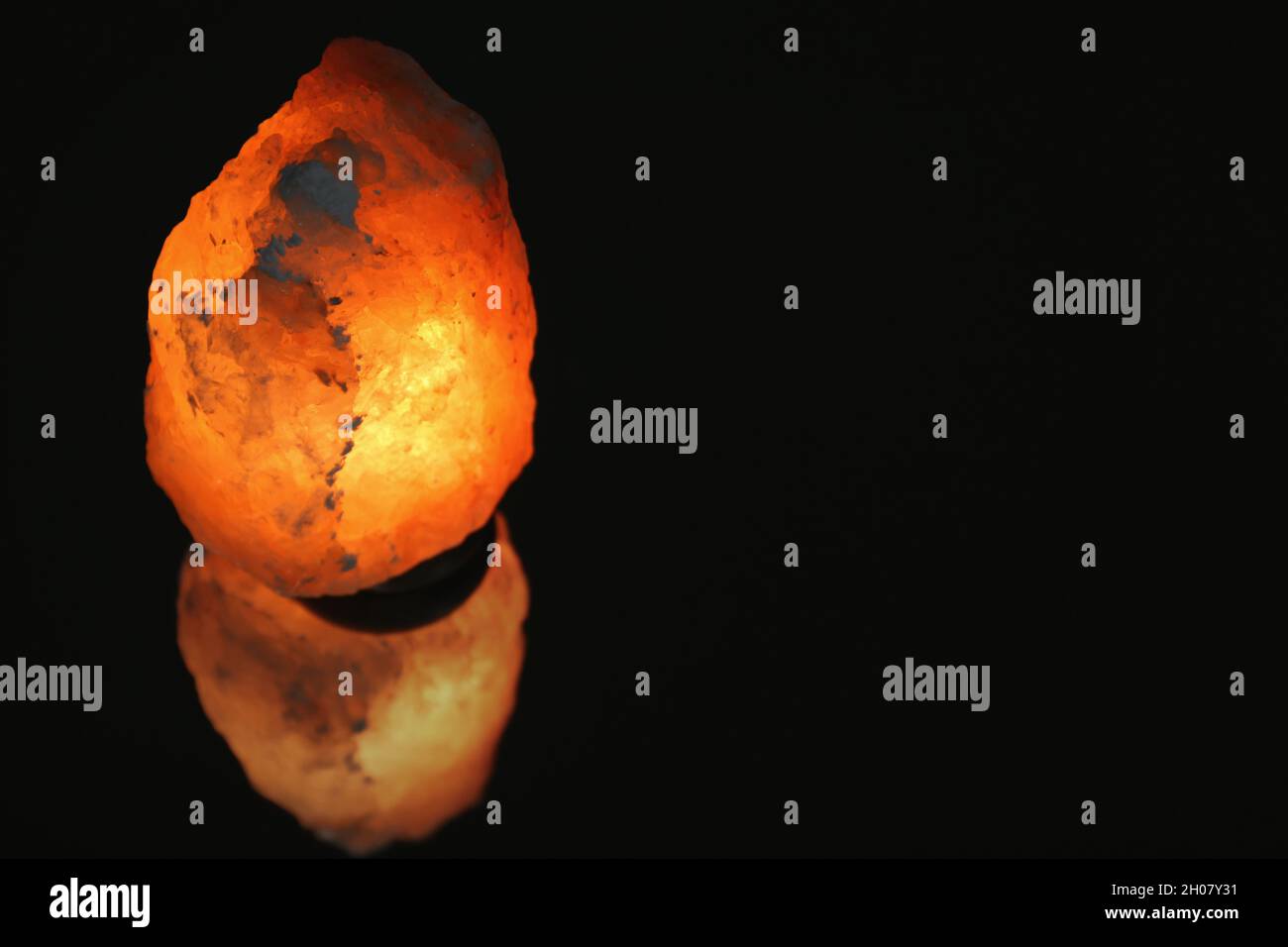 Himalayan salt lamp on black background. Space for text Stock Photo - Alamy