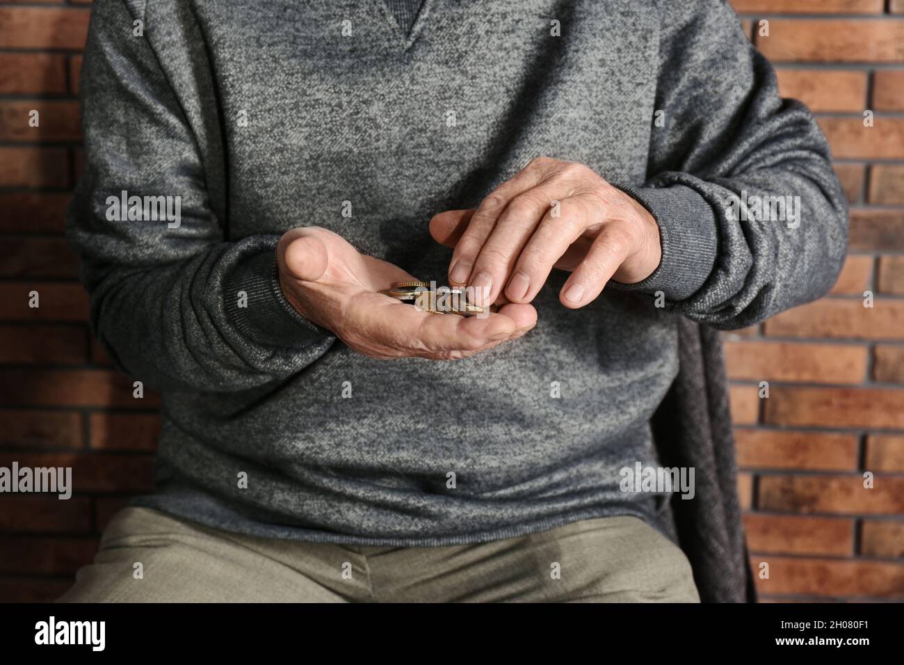Poor elderly man counting coins, focus on hands Stock Photo - Alamy