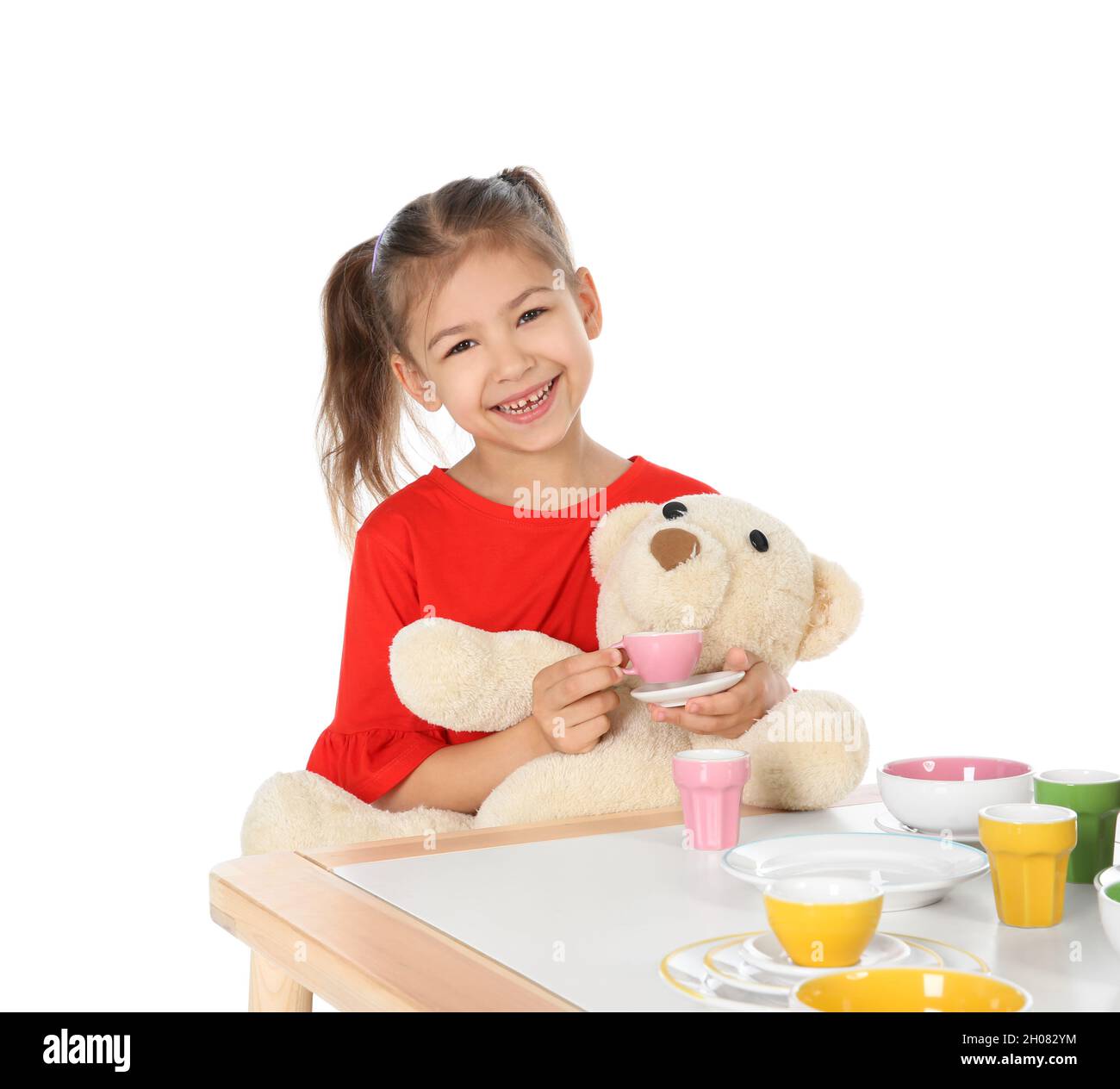 Little child playing tea party with toy on white background. Indoor ...
