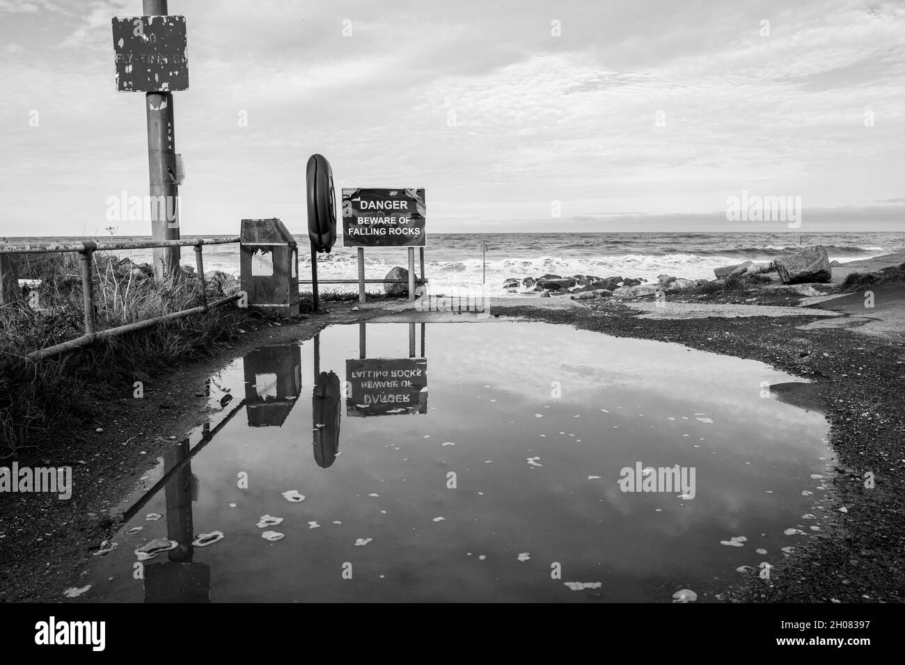 Danger, beware of falling rocks sign at the coastal village of ...