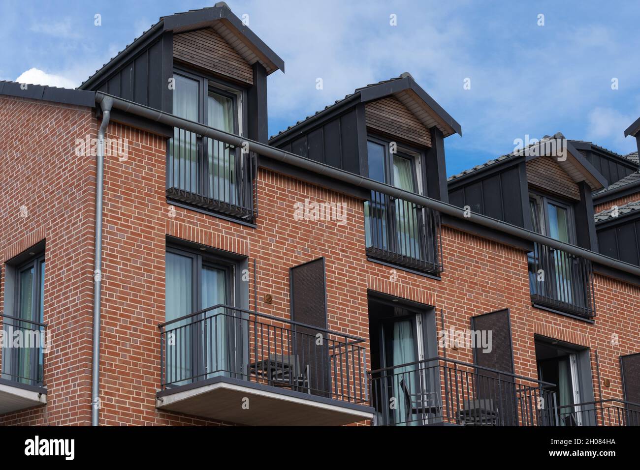 Brick facade of a multi-storey building with beautiful balconies Stock ...