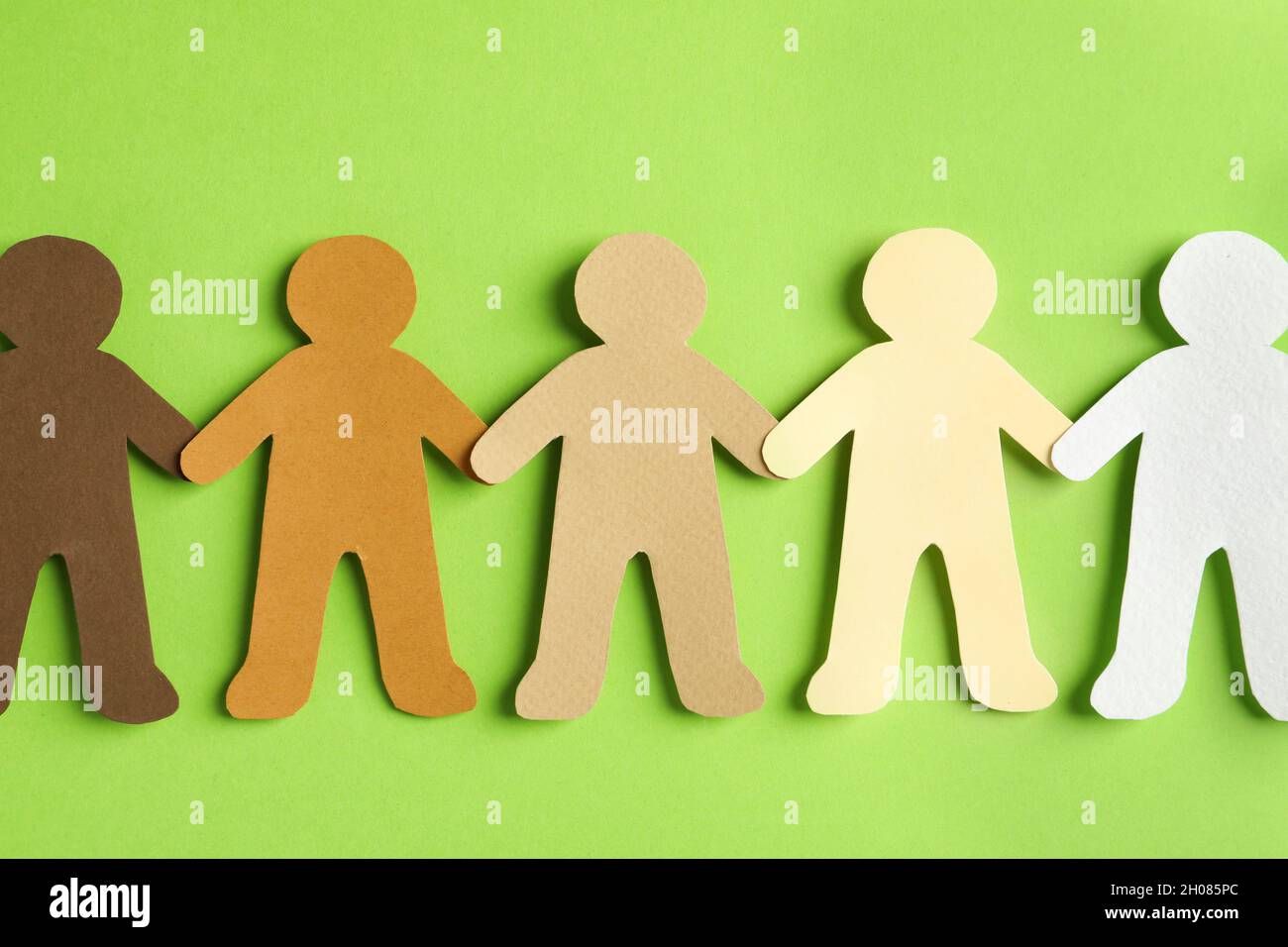 Paper people holding hands on color background, top view. Unity concept ...