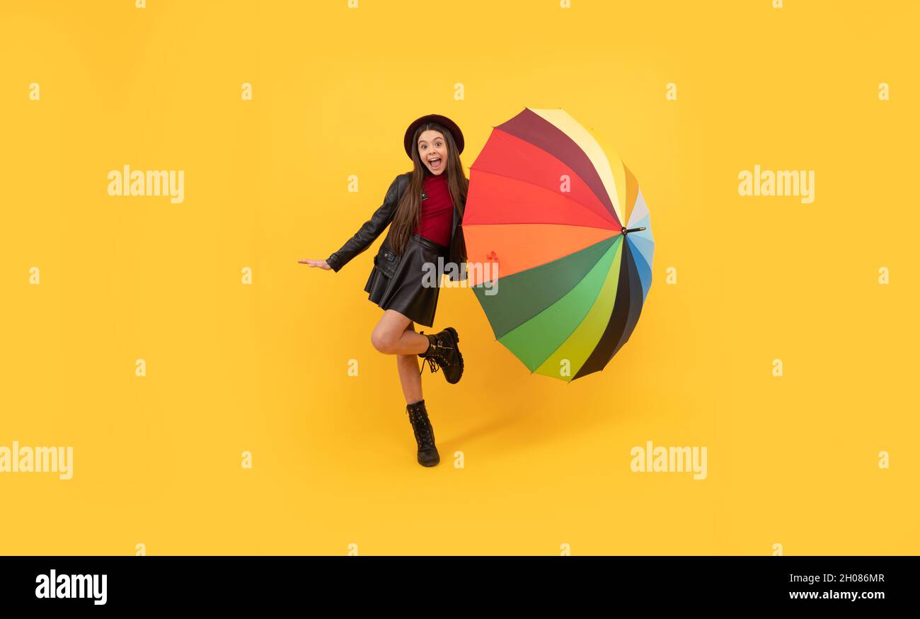 happy teen girl in hat and leather clothes having fun with rainbow ...