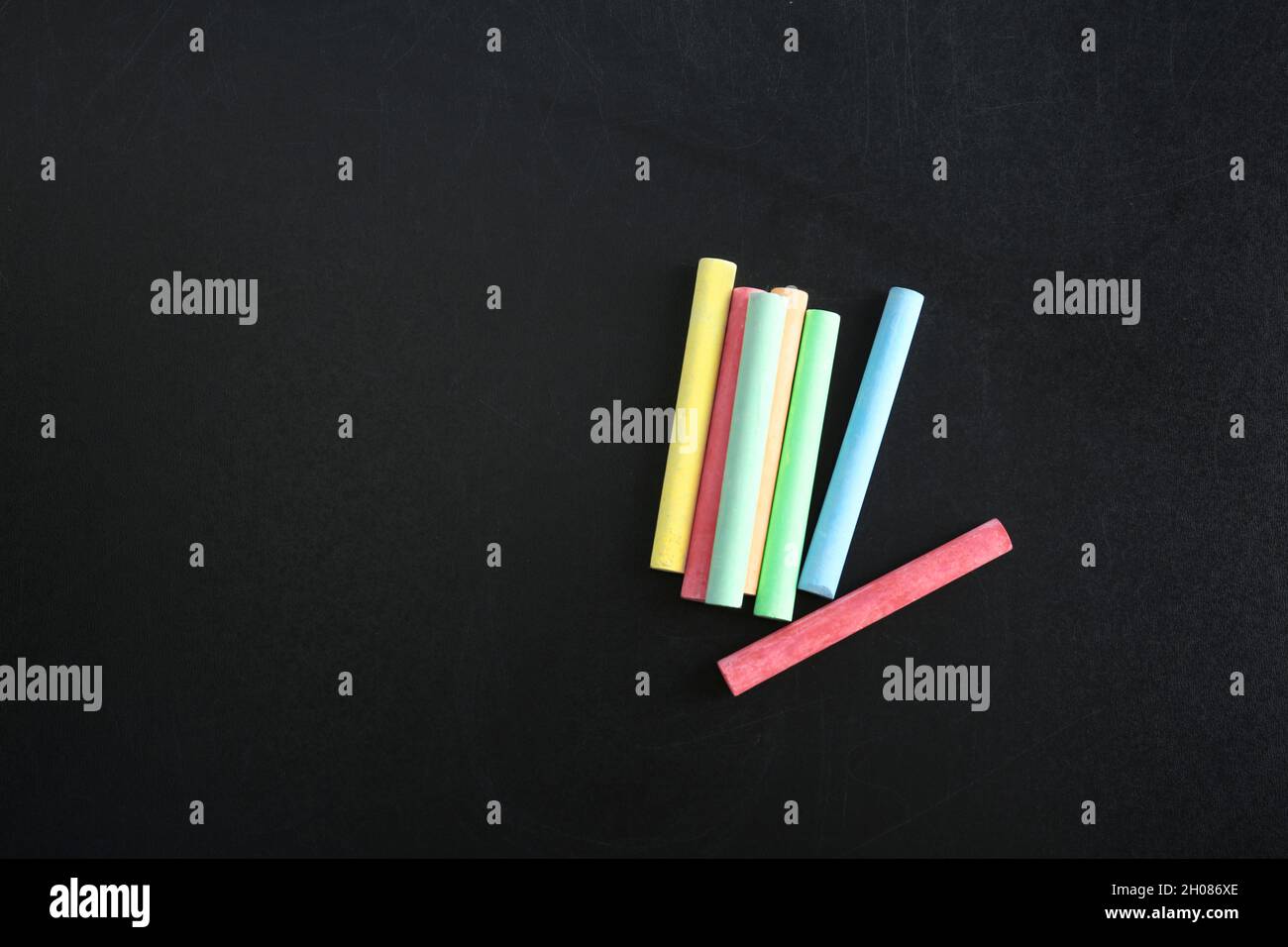 Color pieces of chalk on blackboard, top view Stock Photo - Alamy