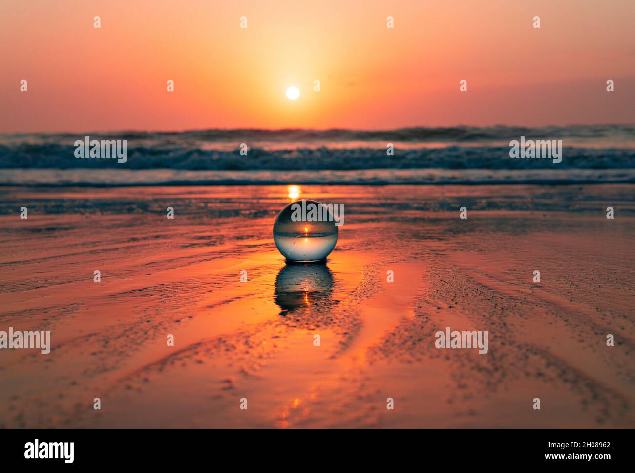 glass ball on sandy vacation beach colorful sunrise Stock Photo - Alamy