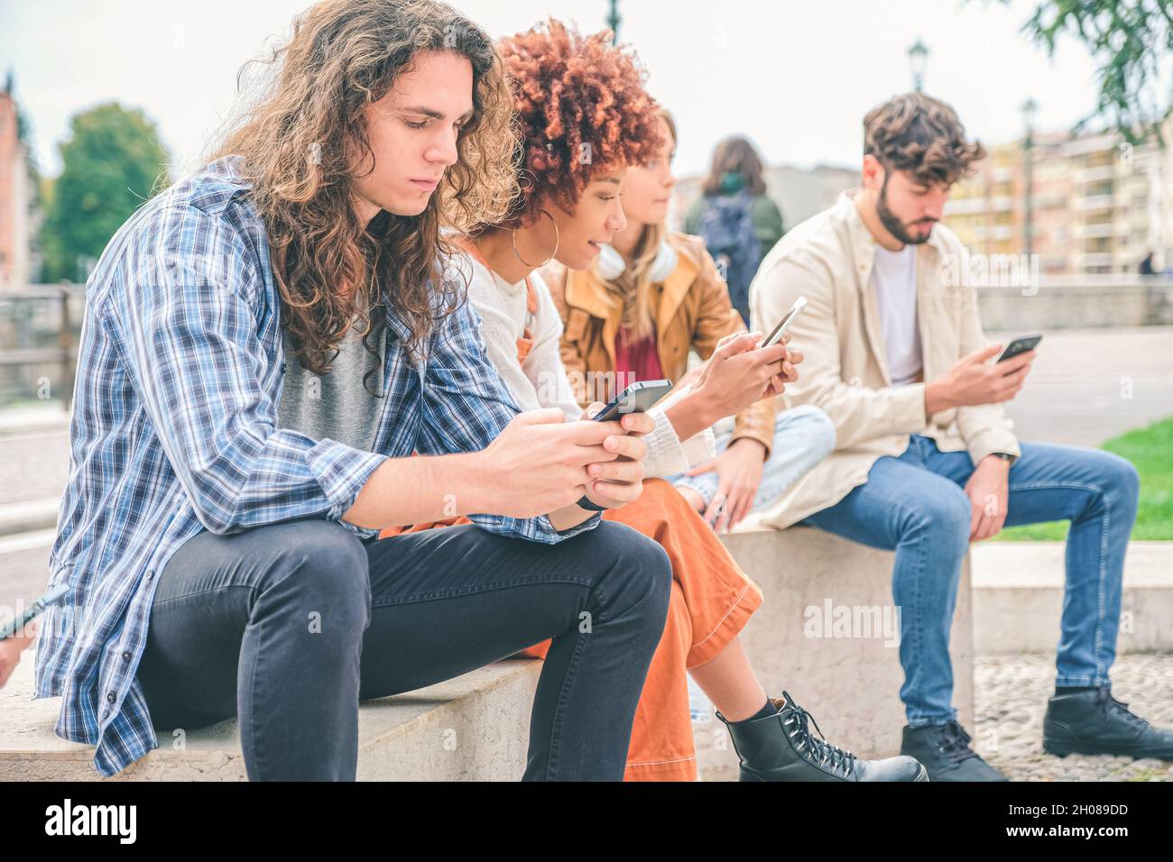 Multicultural group of friends using mobile phones - Students sitting ...