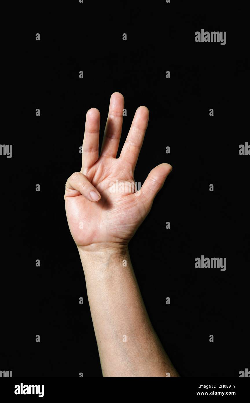 Vertical shot of a hand showing Number 4 on a dark background Stock ...