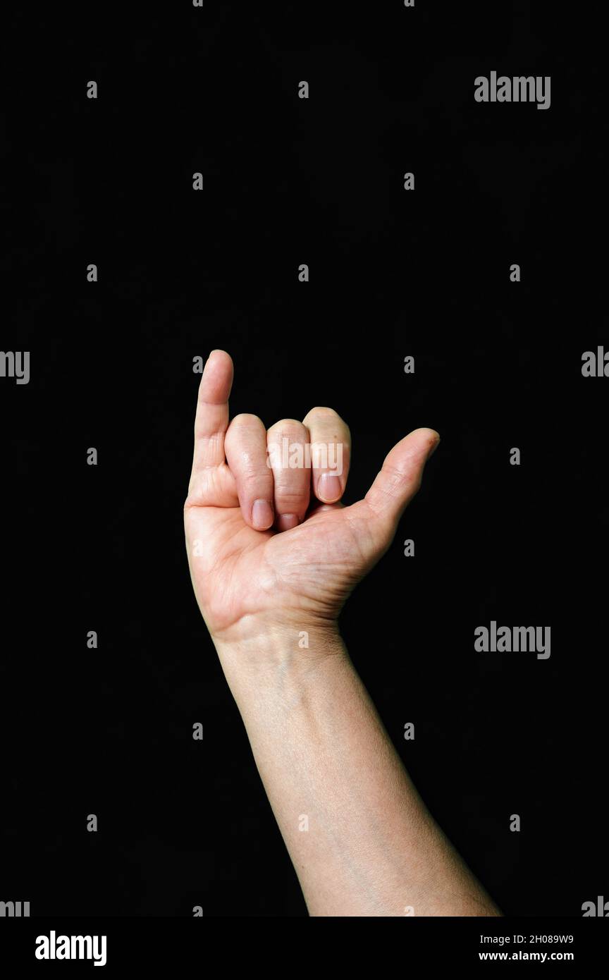 Vertical shot of a hand showing the letter G on a dark background Stock ...