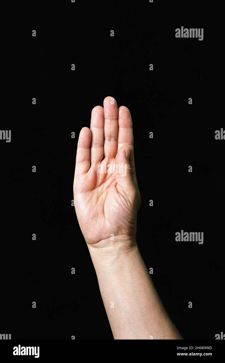Vertical shot of a hand showing the letter B on a dark background Stock ...