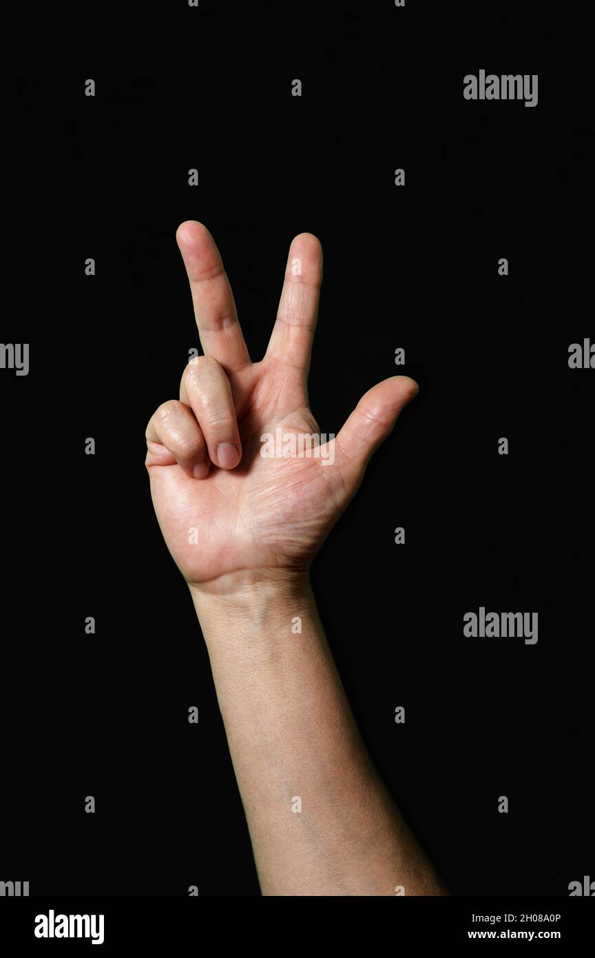 Vertical shot of a hand showing Number 3 on a dark background Stock ...