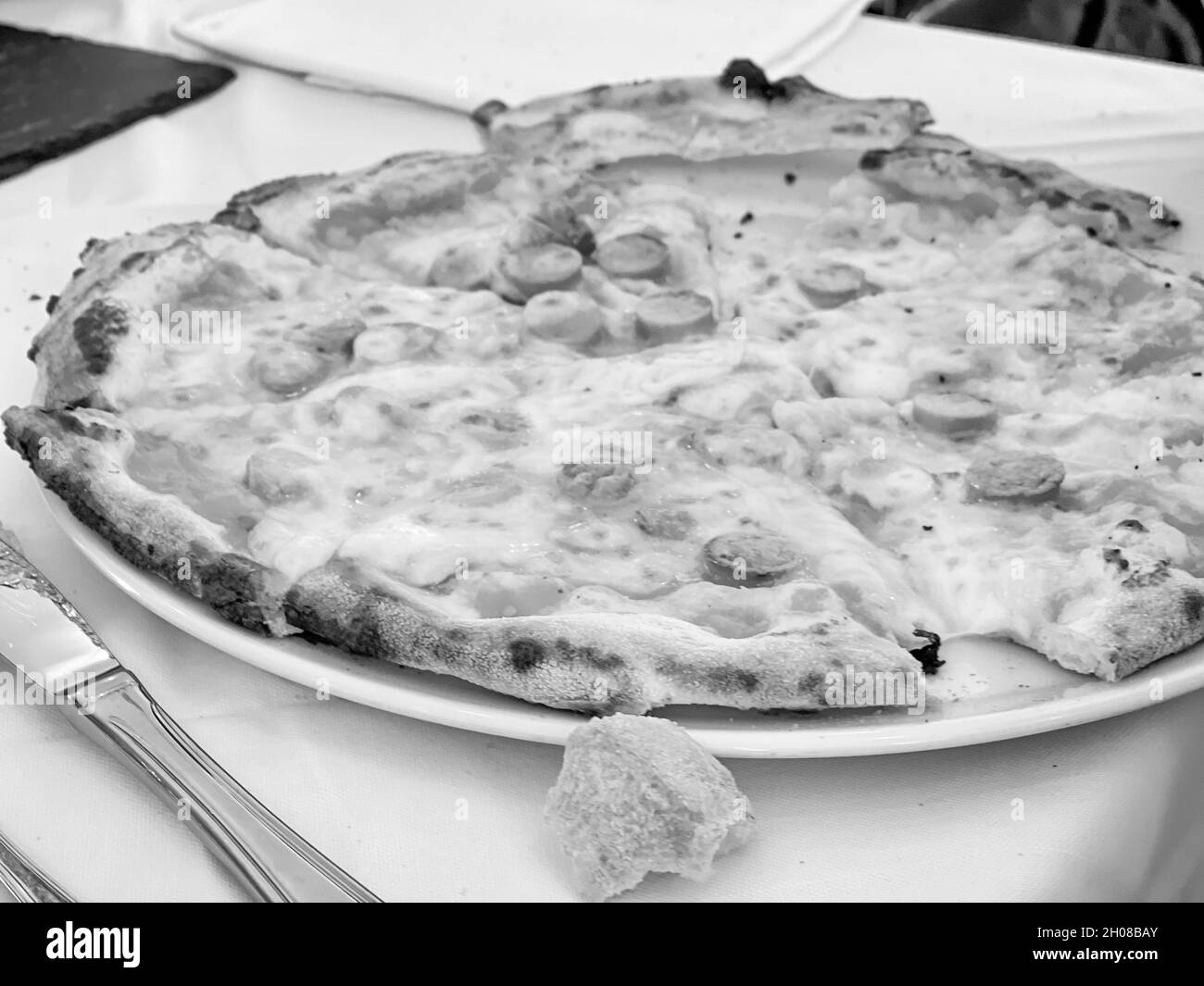 Grayscale shot of a whole delicious pepperoni pizza Stock Photo - Alamy