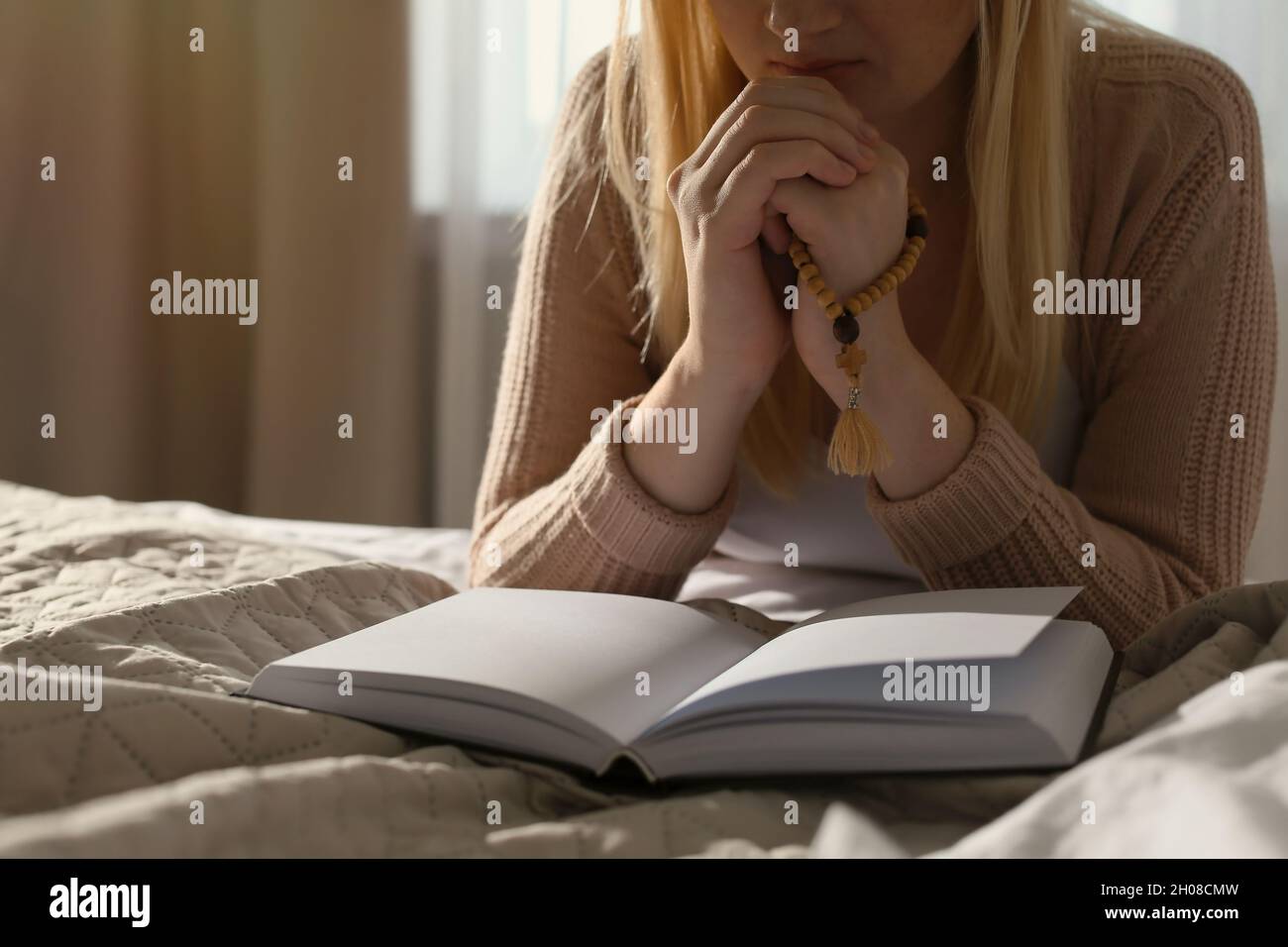 Religious young woman praying over Bible in bedroom Stock Photo - Alamy