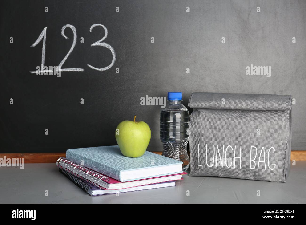 Healthy food for school child in lunch bag and stationery on table near ...