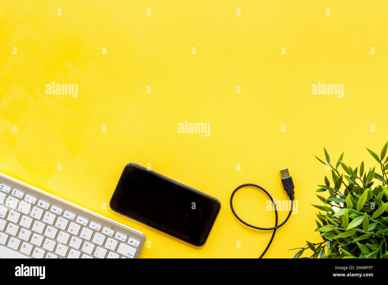 Cables for charging smartphone or laptop on office table, top view ...