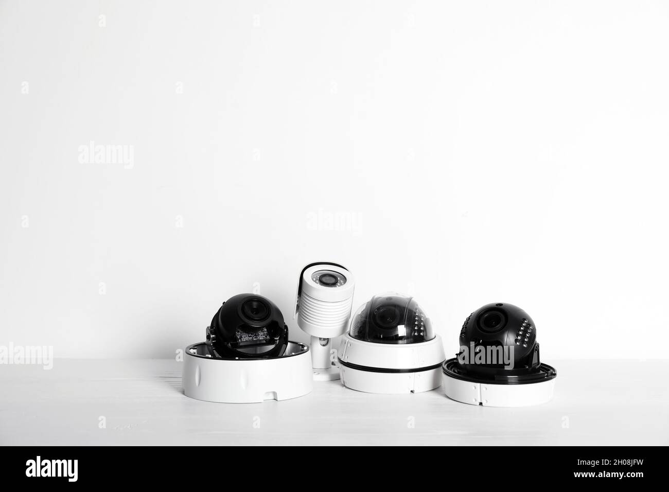 Modern CCTV cameras on table against light background. Home alarm ...