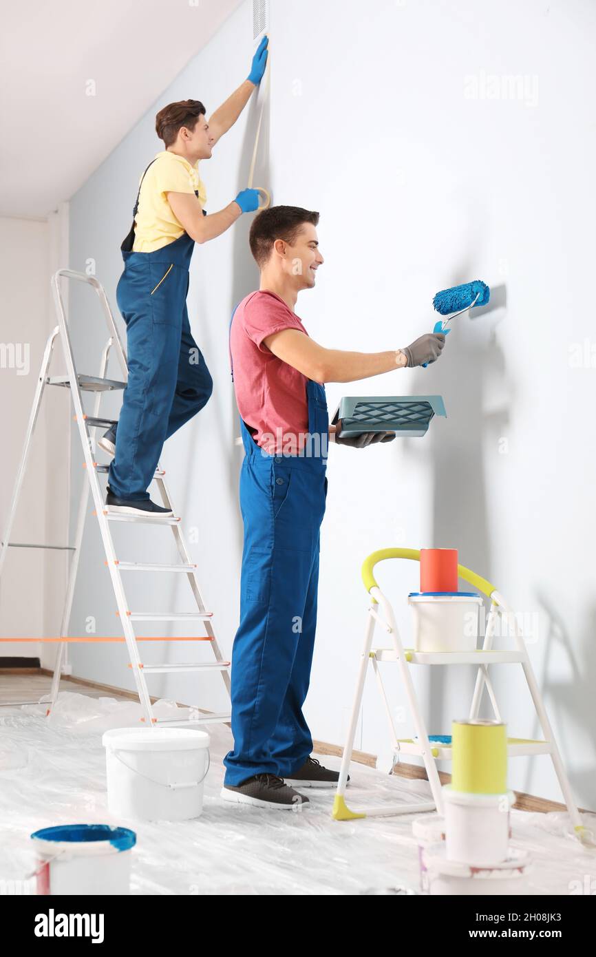 Male decorators refurbishing empty room Stock Photo - Alamy