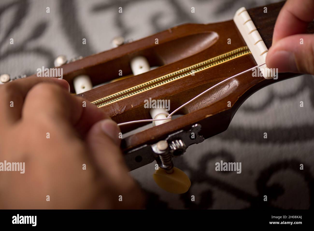 Restring classical guitar concept. The man restring his classical ...