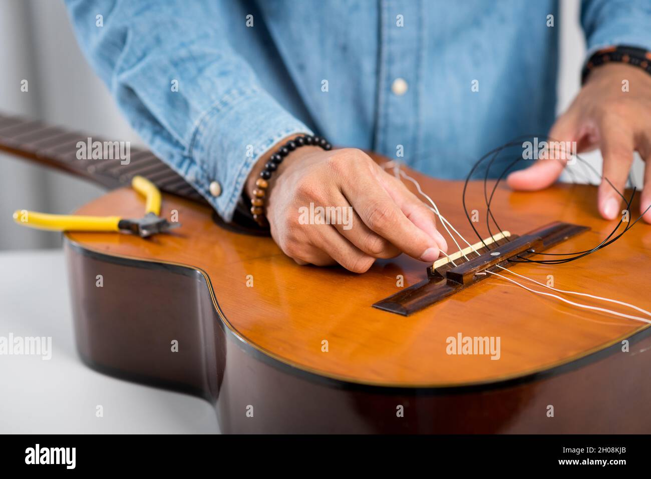 Restring classical guitar concept. The man restring his classical ...