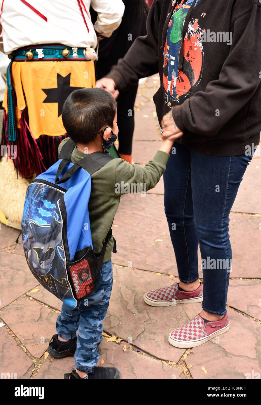 A Native American woman and her young son hold hands as they wait for ...