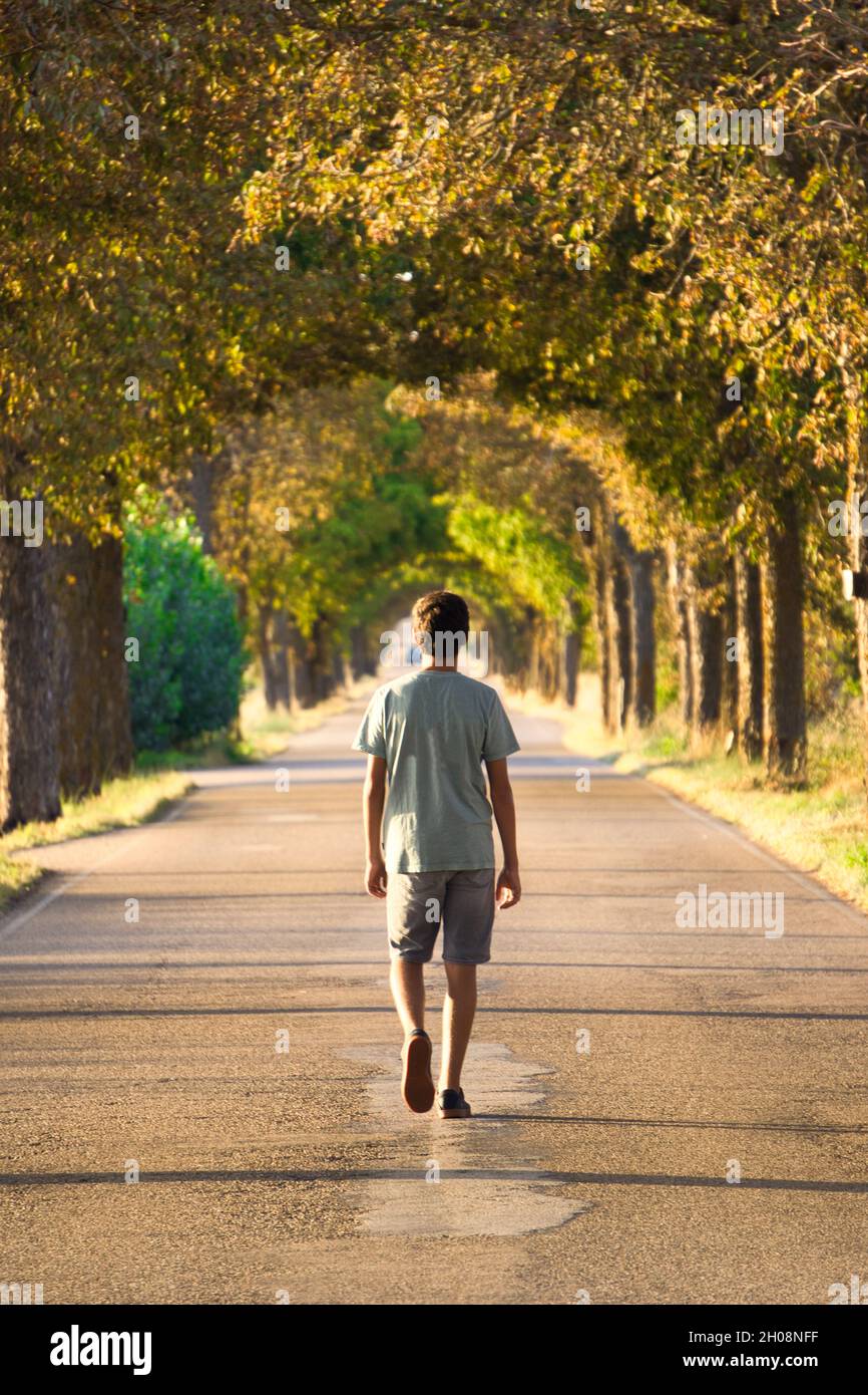 Vertical shot of aHispanic boy walking down a path in the park Stock ...