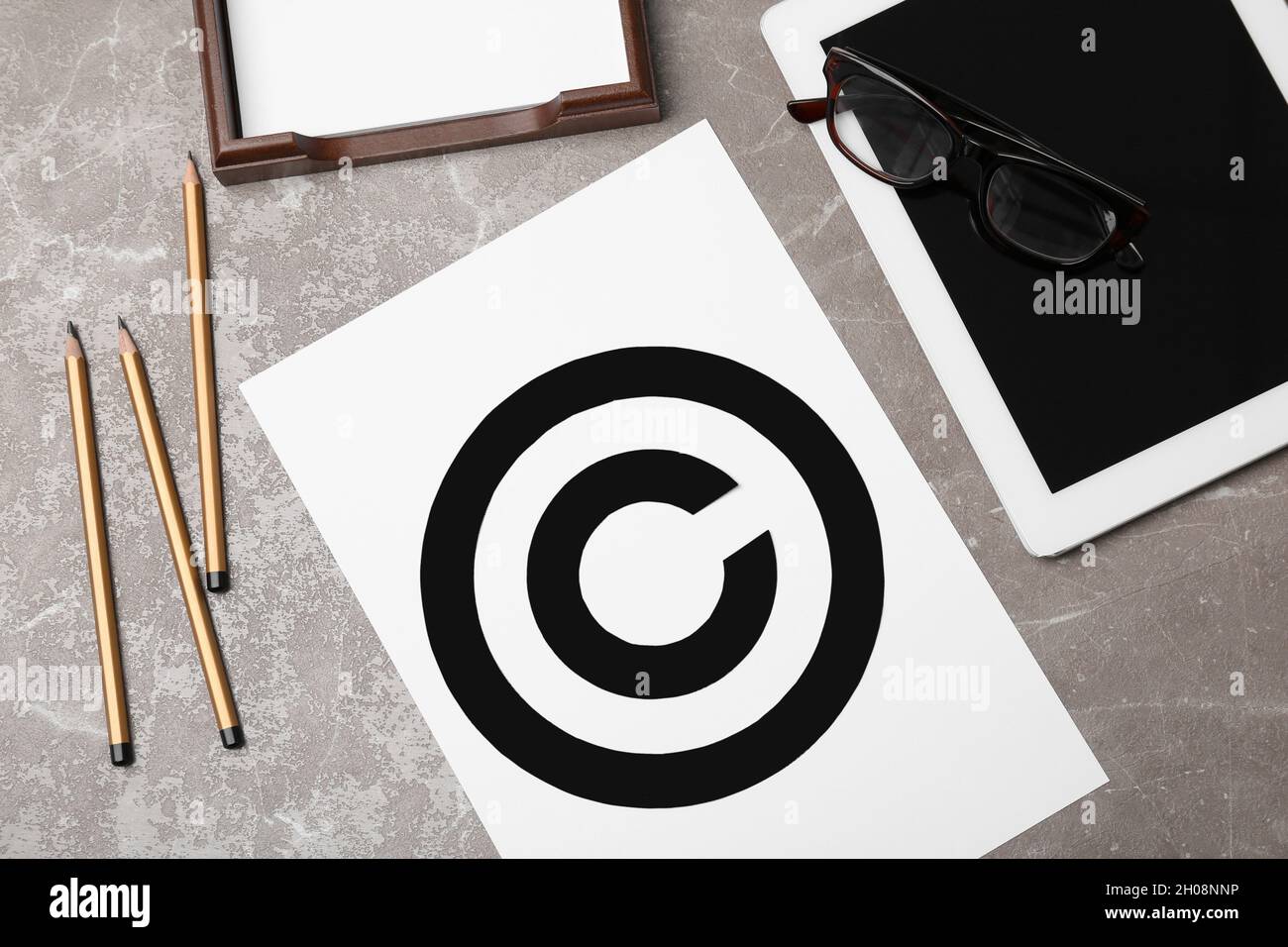 Sheet of paper with copyright symbol and tablet on grey background. Law ...