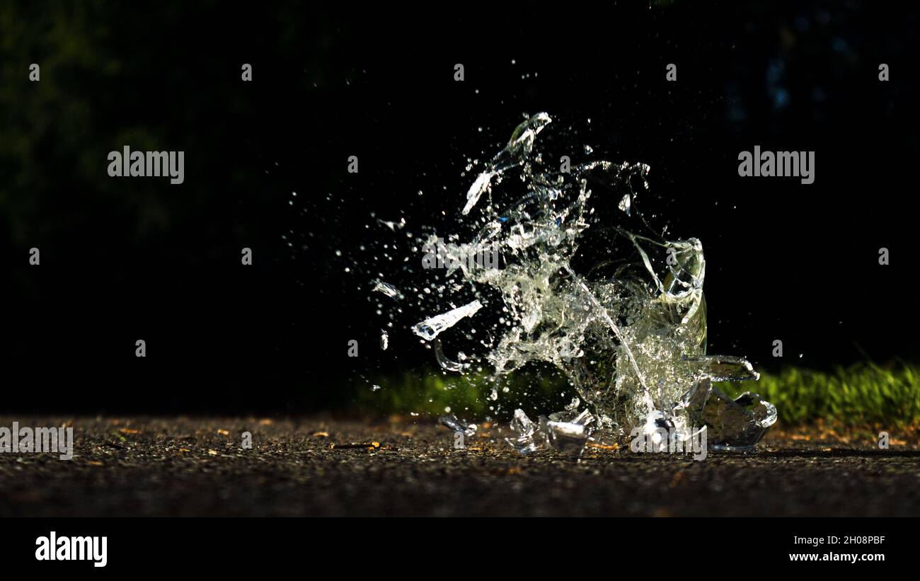 Shot of glass breaking and the water pouring out Stock Photo - Alamy
