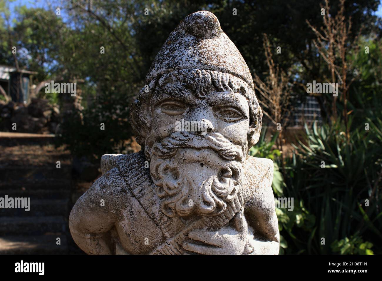 Selective focus shot of a dwarf stone statue in a park Stock Photo - Alamy