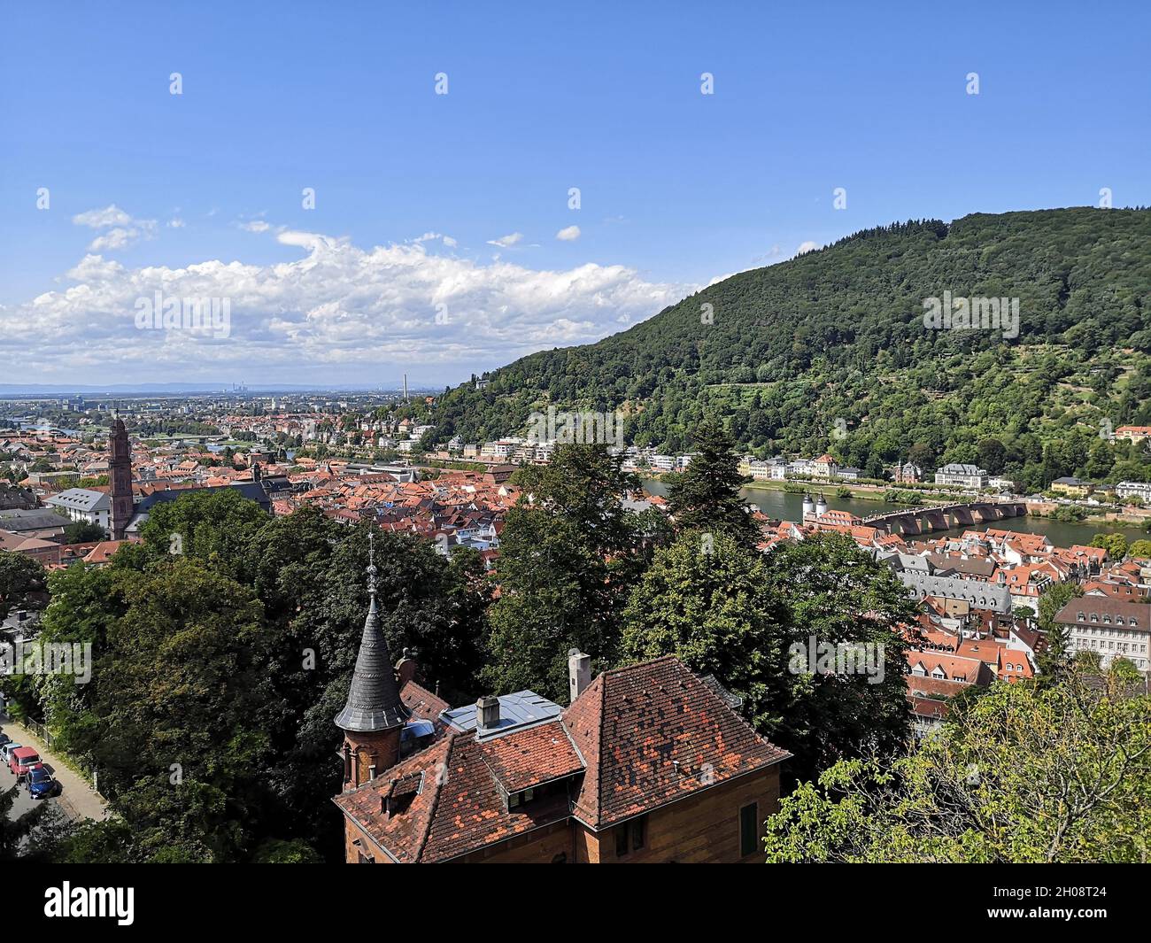 Cityscape of Heidelberg surrounded by hills and greenery on a sunny day ...